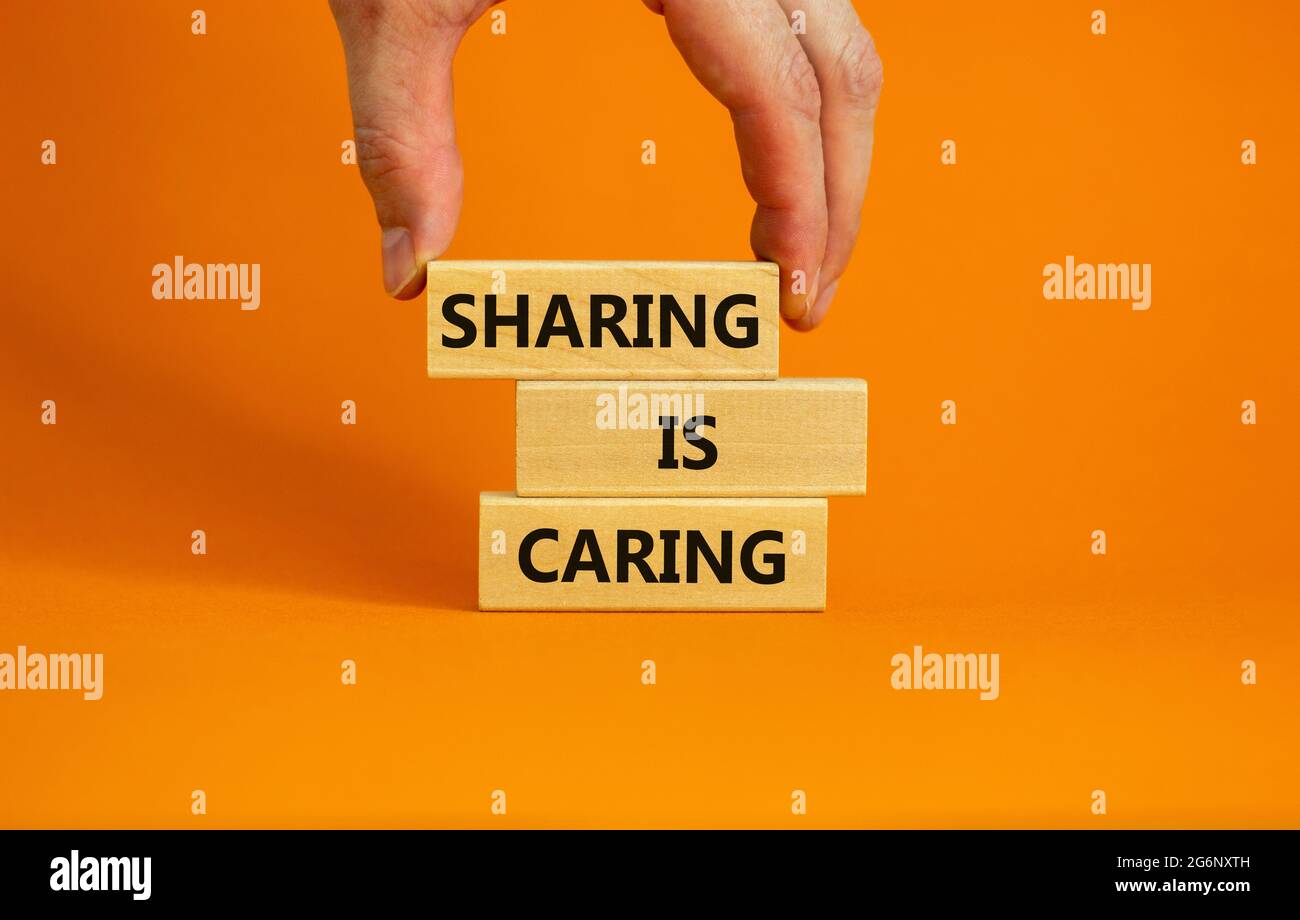 Sharing is caring symbol. Wooden blocks with words 'Sharing is caring ...