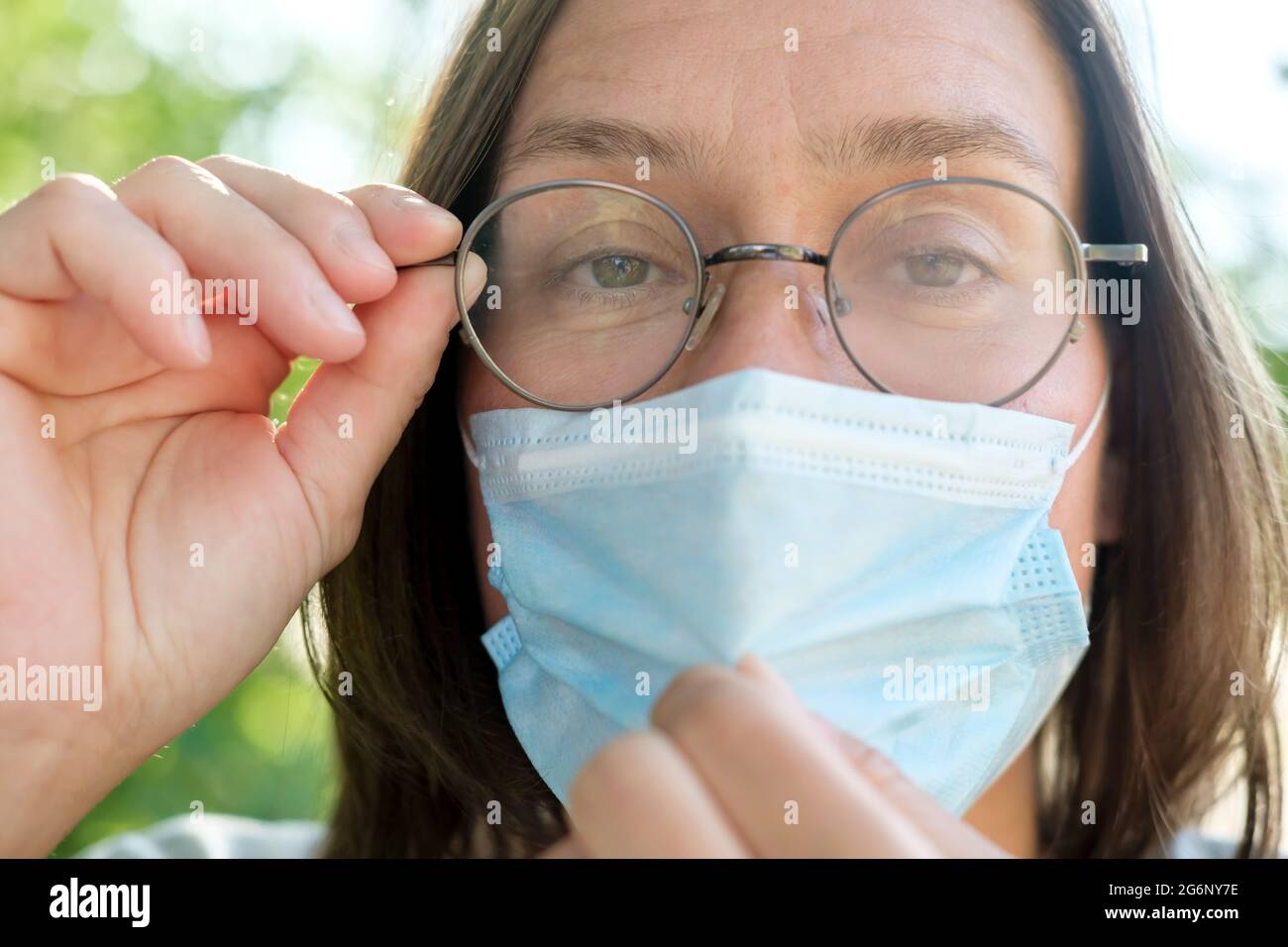 Woman wearing foggy glasses due to wearing a medical mask ...