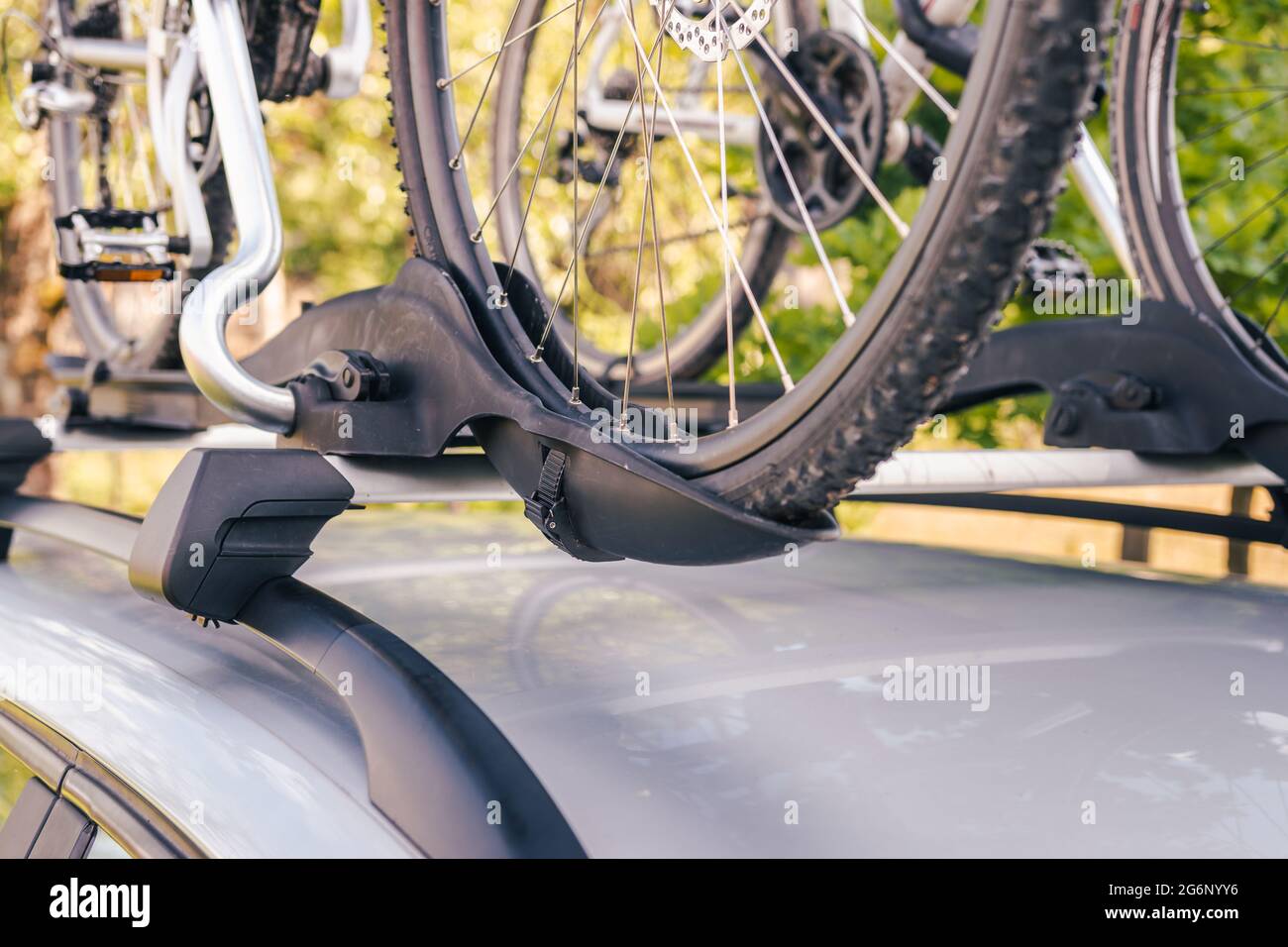 Bicycle installed to roof bike rack on a silver car, coutryside ...
