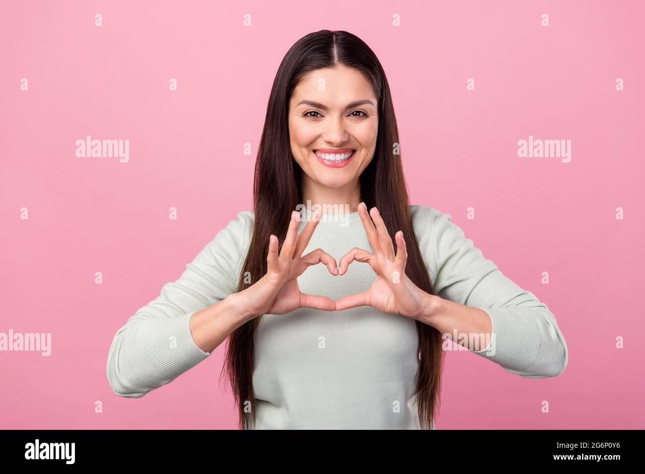 Photo of lovely happy charming young woman make fingers heart shape ...