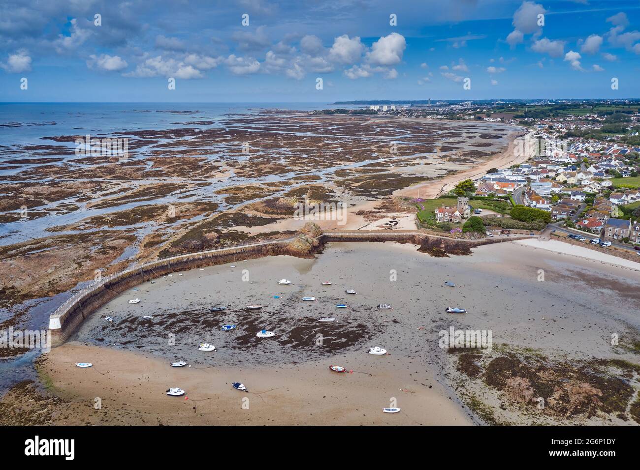 Image of La Rocque Harbour at half tide with blue sky and beached boats ...