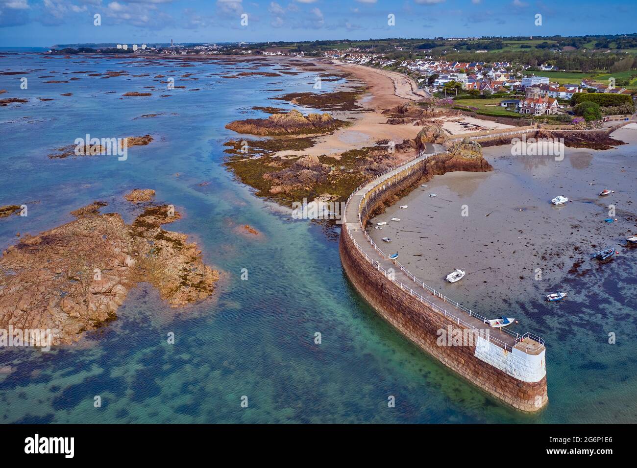 Image of La Rocque Harbour at half tide with blue sky and beached boats ...