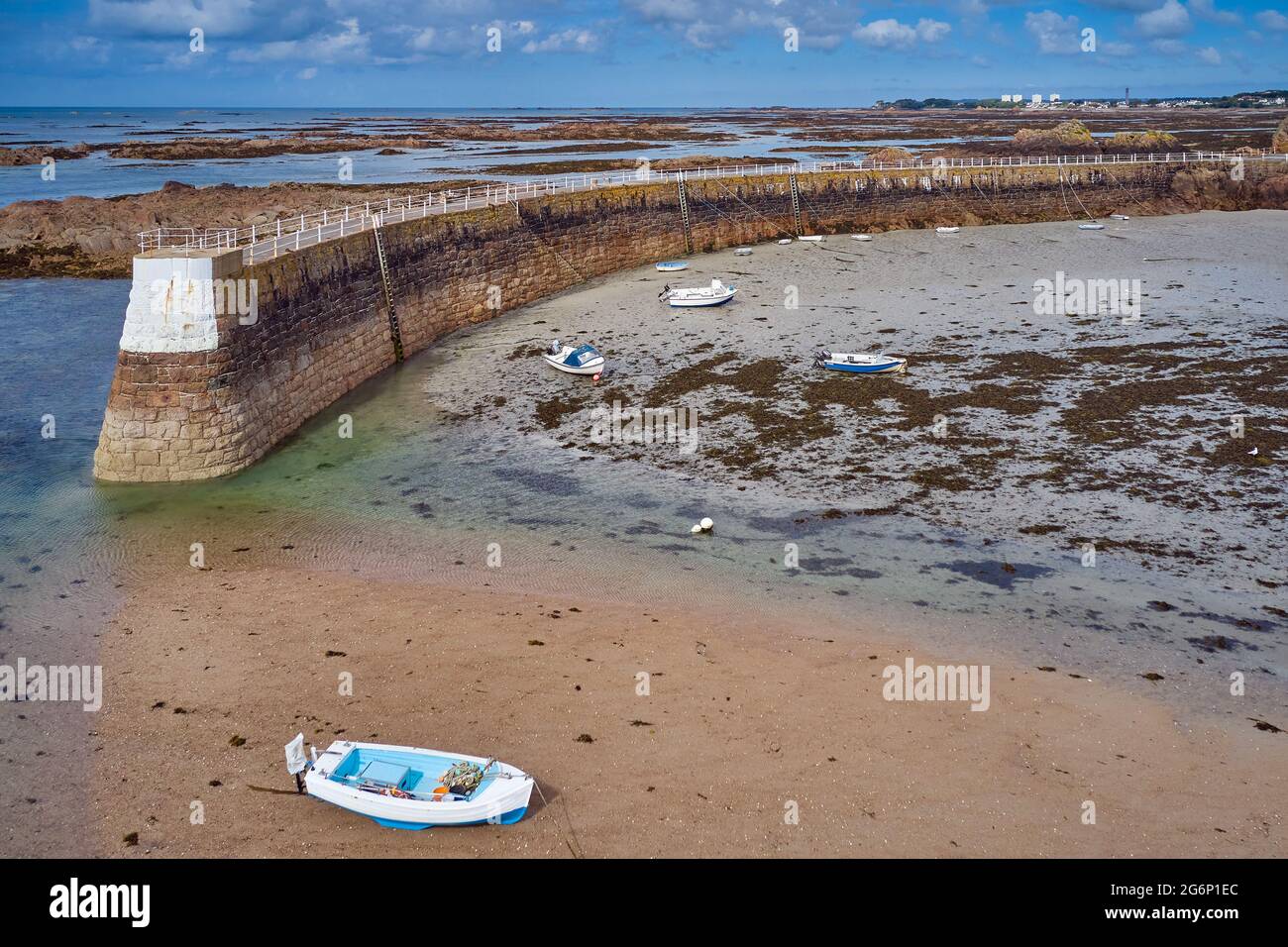 Image of La Rocque Harbour at half tide with blue sky and beached boats ...