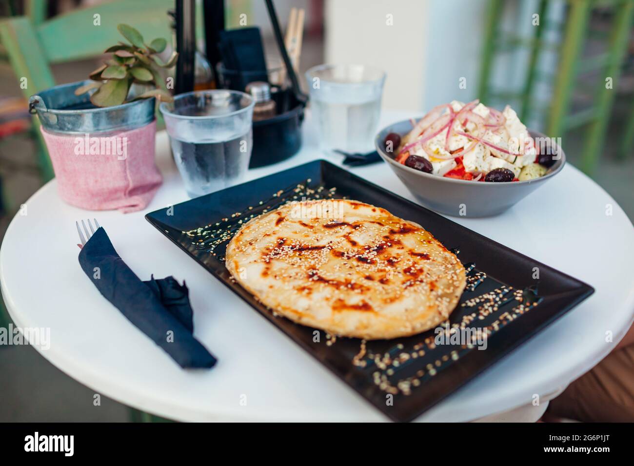 Greek soft pita, stuffed with cheese sprinkled with sesame seeds, honey ...