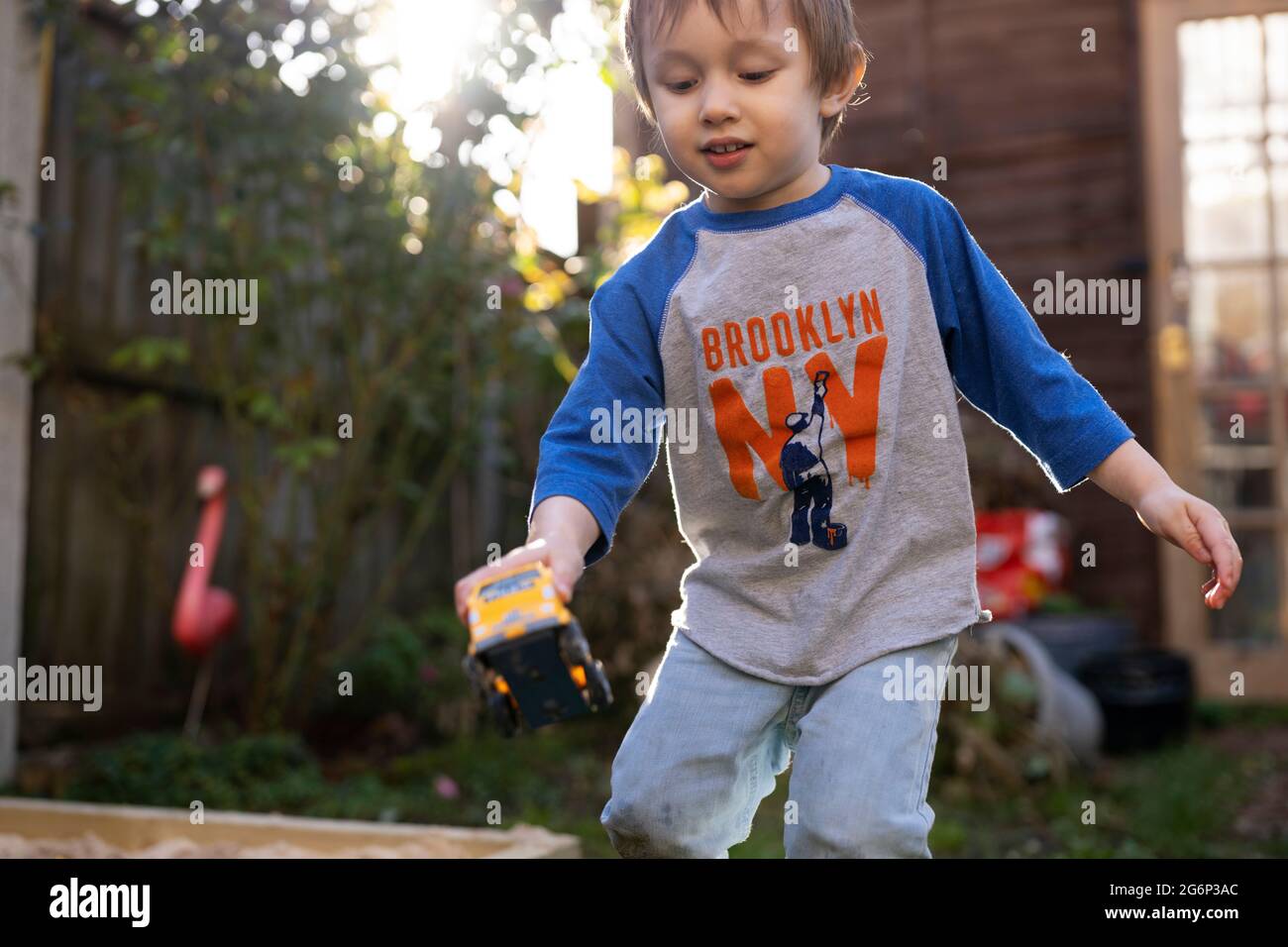 A young boy playing with toys outdoors Stock Photo - Alamy