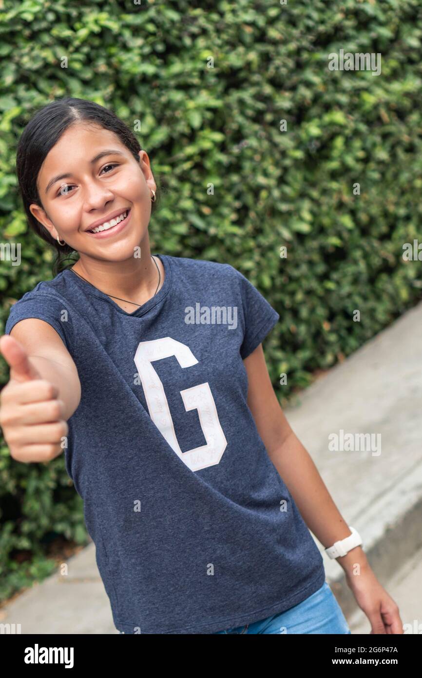 teenager making positive hand gesture, thumbs up smiling and happy ...