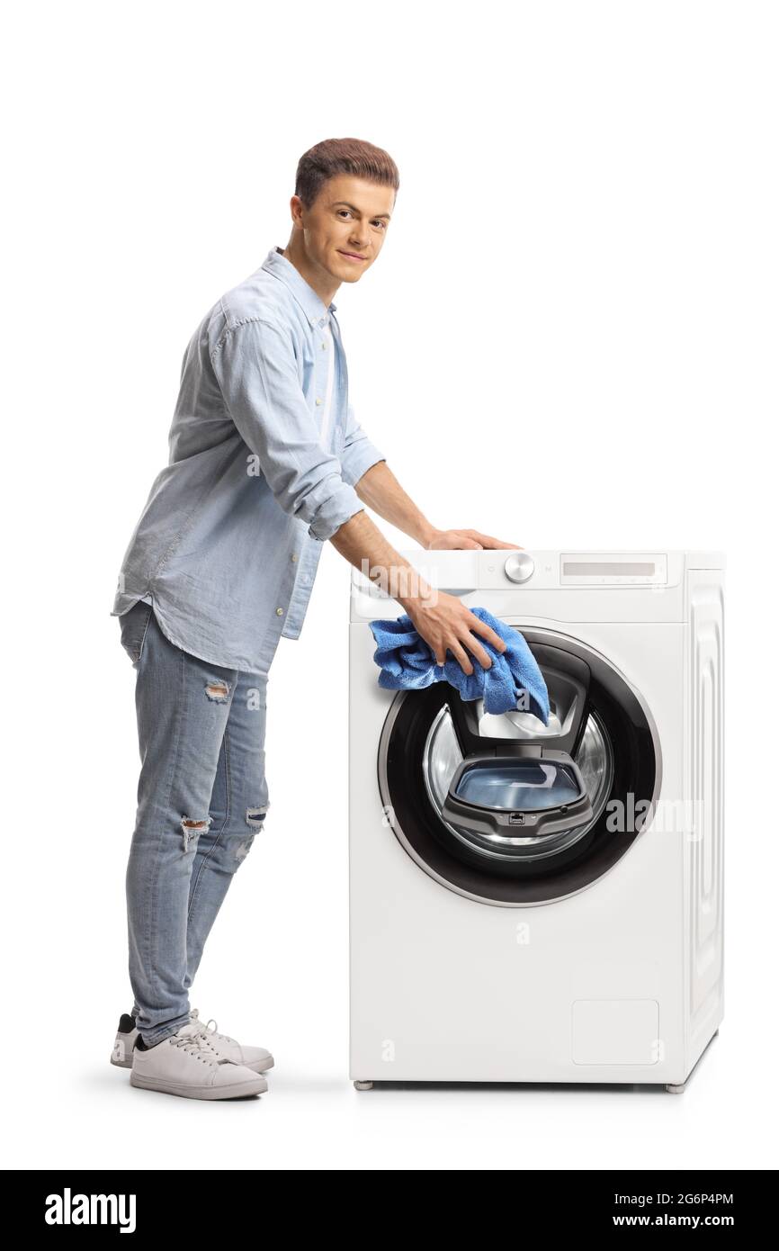 Young man loading a washing machine and looking at camera isolated on ...