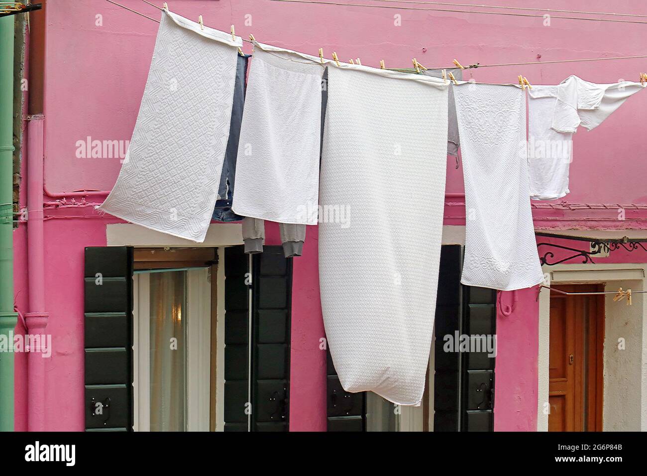 Wet laundry on a string drying outdoors on house facade Stock Photo - Alamy
