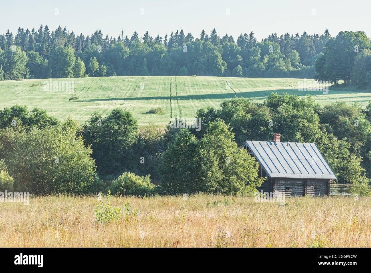 Wooden house by the lake at summer sunset. Summer countryside view ...