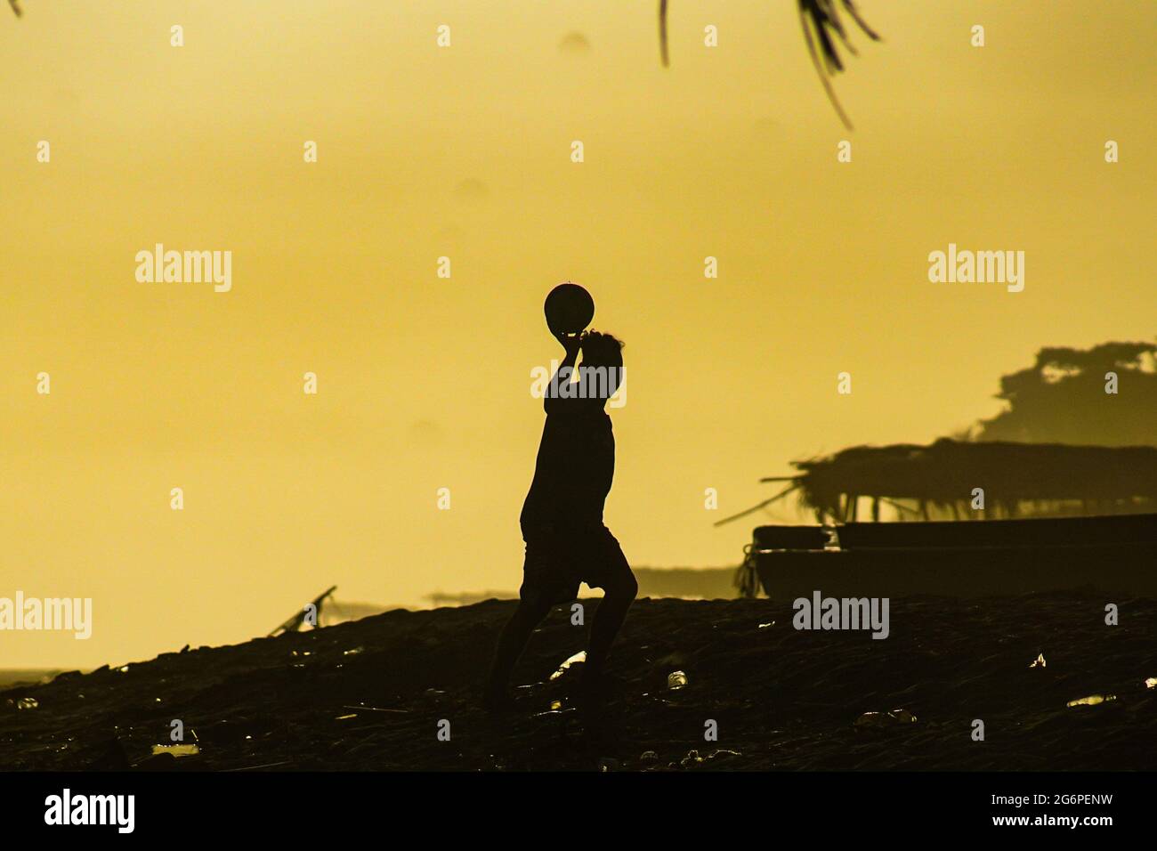 A man plays soccer at San Marcelino beach during sunset. (Photo by ...