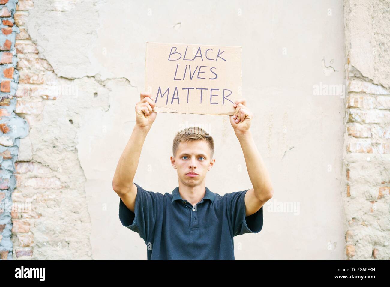 Poster that says black life matters in the hands of a young man ...