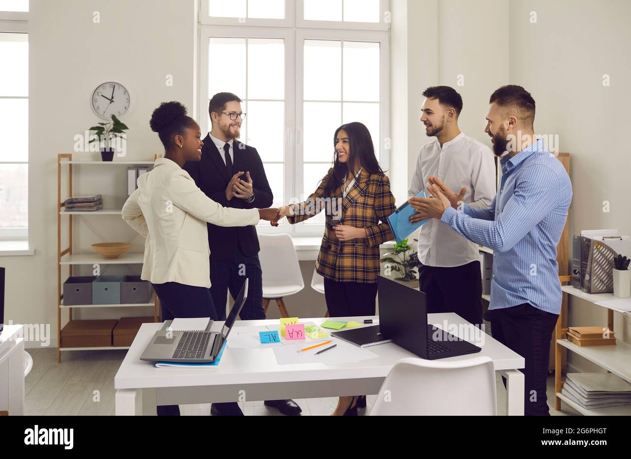 Happy diverse business teams making a deal and shaking hands in an ...