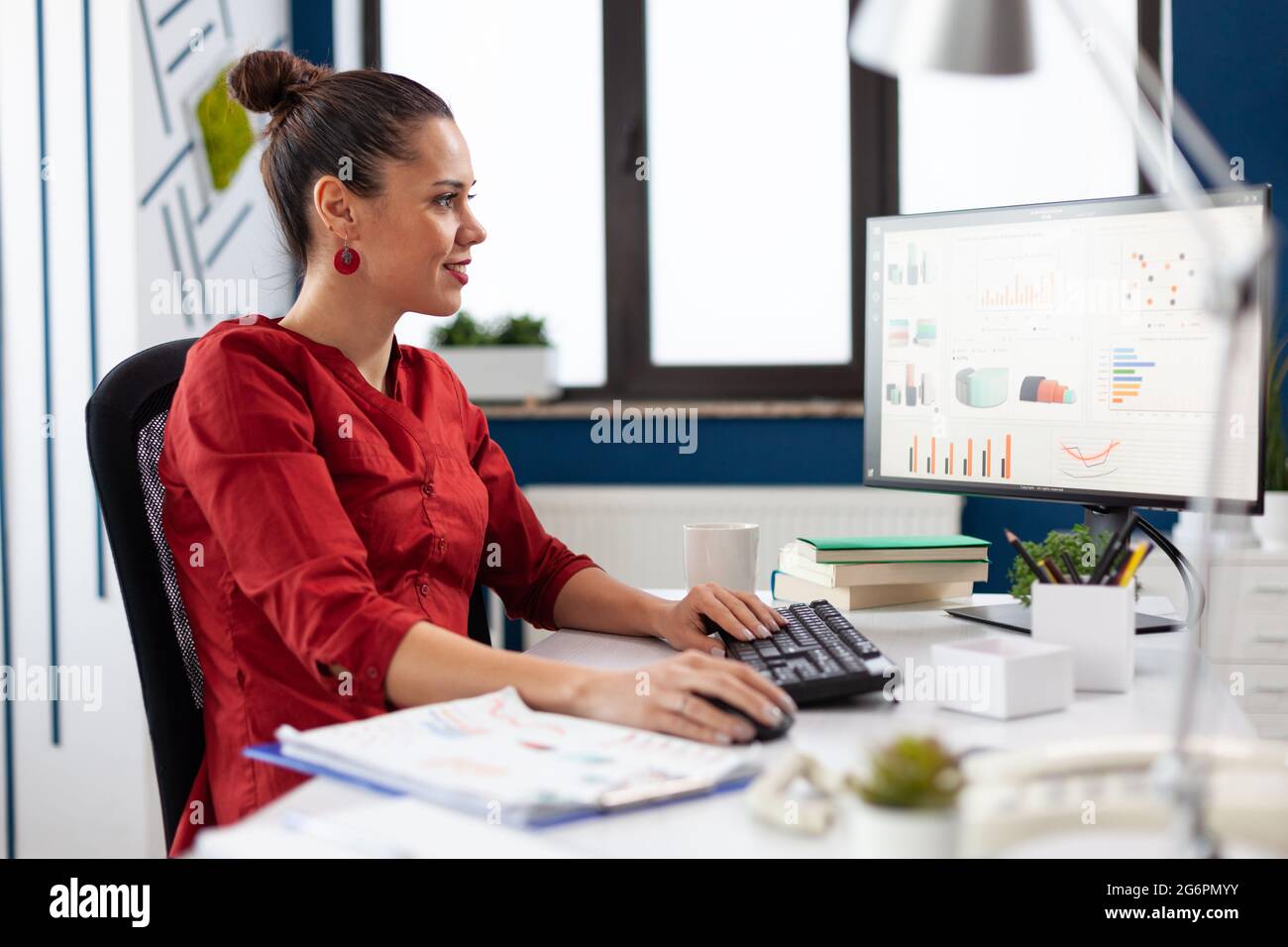 Successful businesswoman working on computer in company office ...