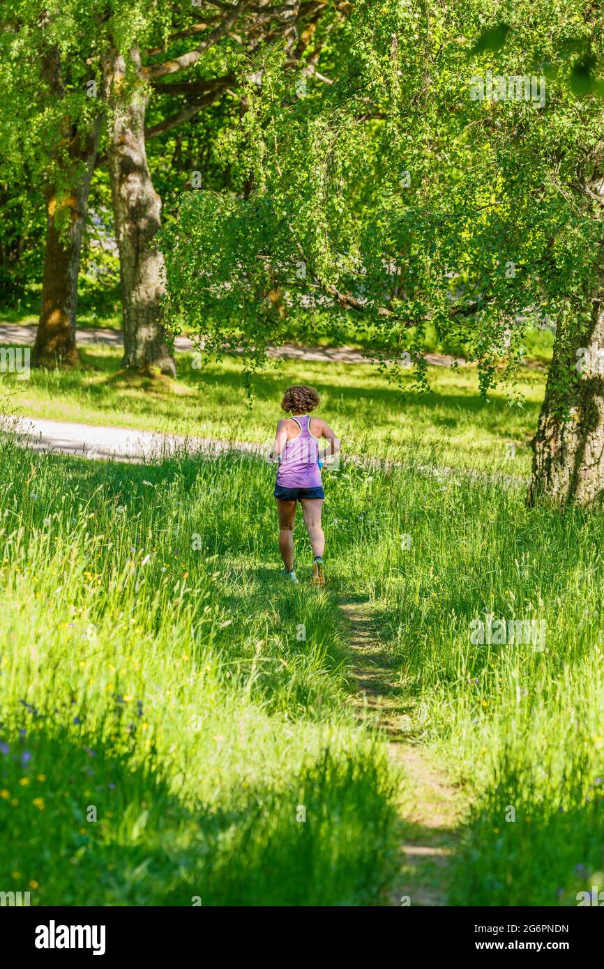 Woman running on a path in a pasture Stock Photo - Alamy