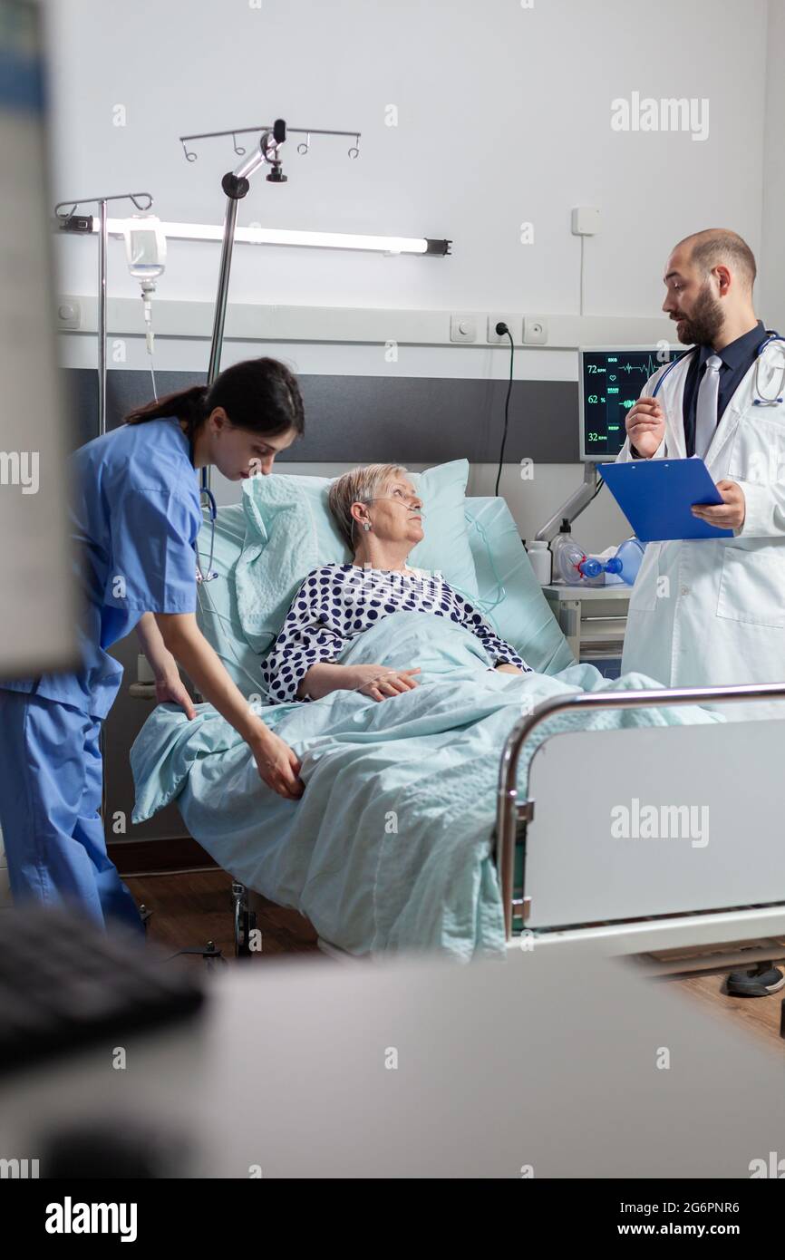 Medical staff checking senior woman health condition in hospital with ...