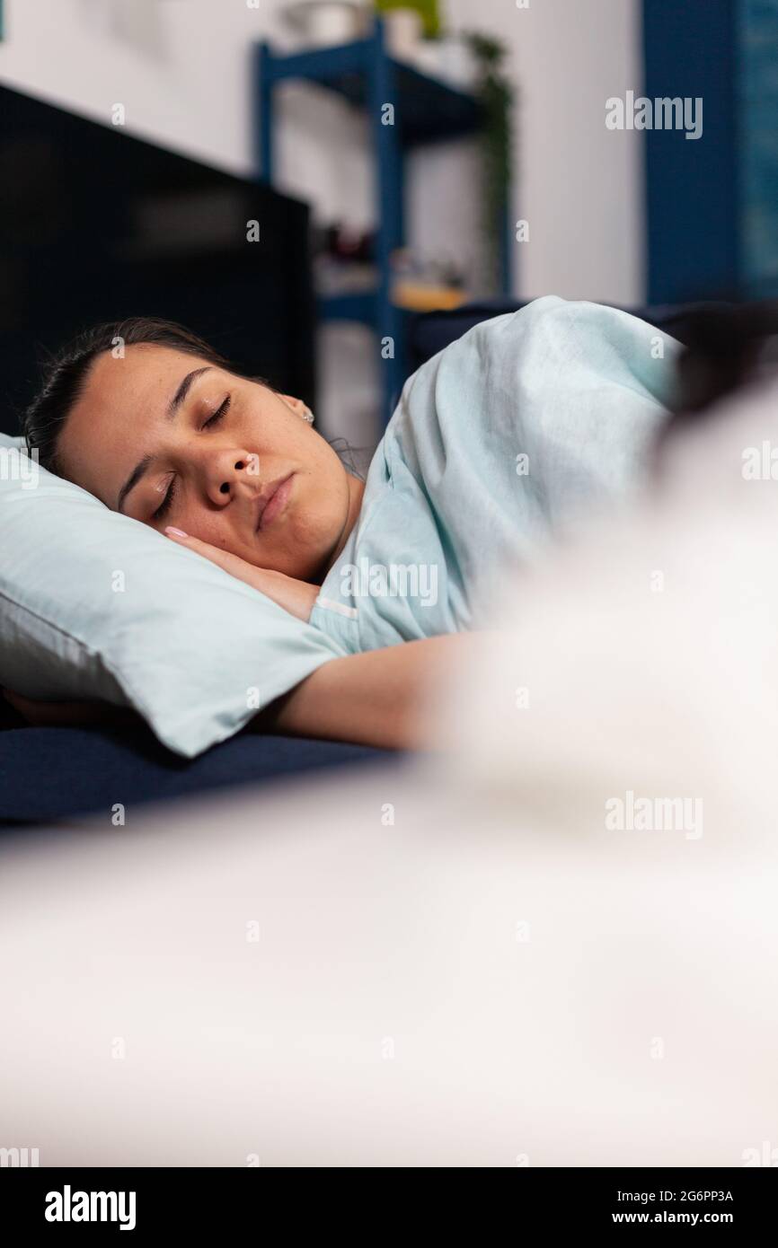 Woman feeling sick sleeping at home on the couch, recovering after cold ...