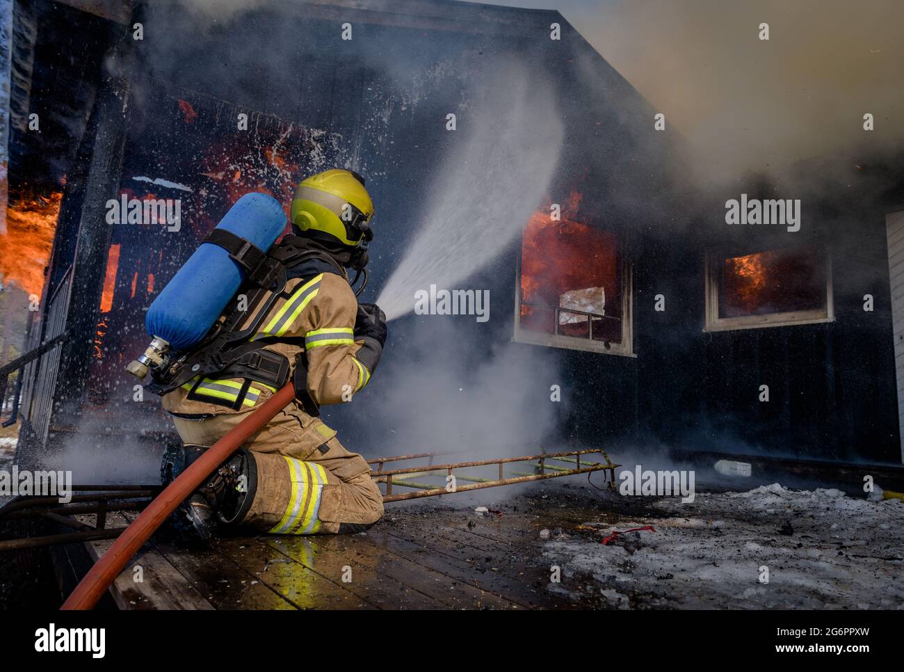 Firefighters trying to put out flames cabin on fire Stock Photo - Alamy