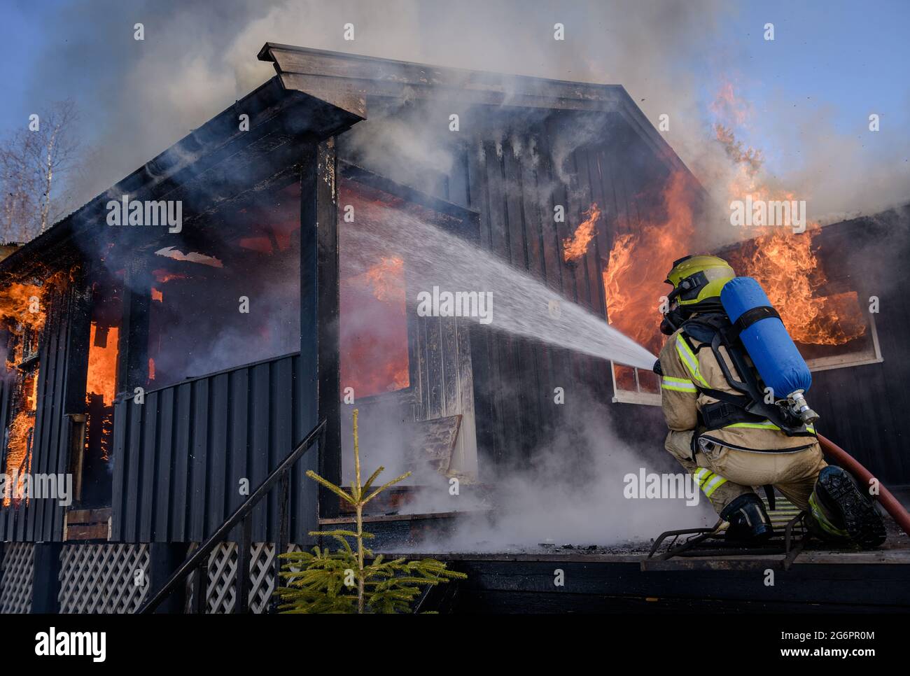Firefighters trying to put out flames cabin on fire Stock Photo - Alamy