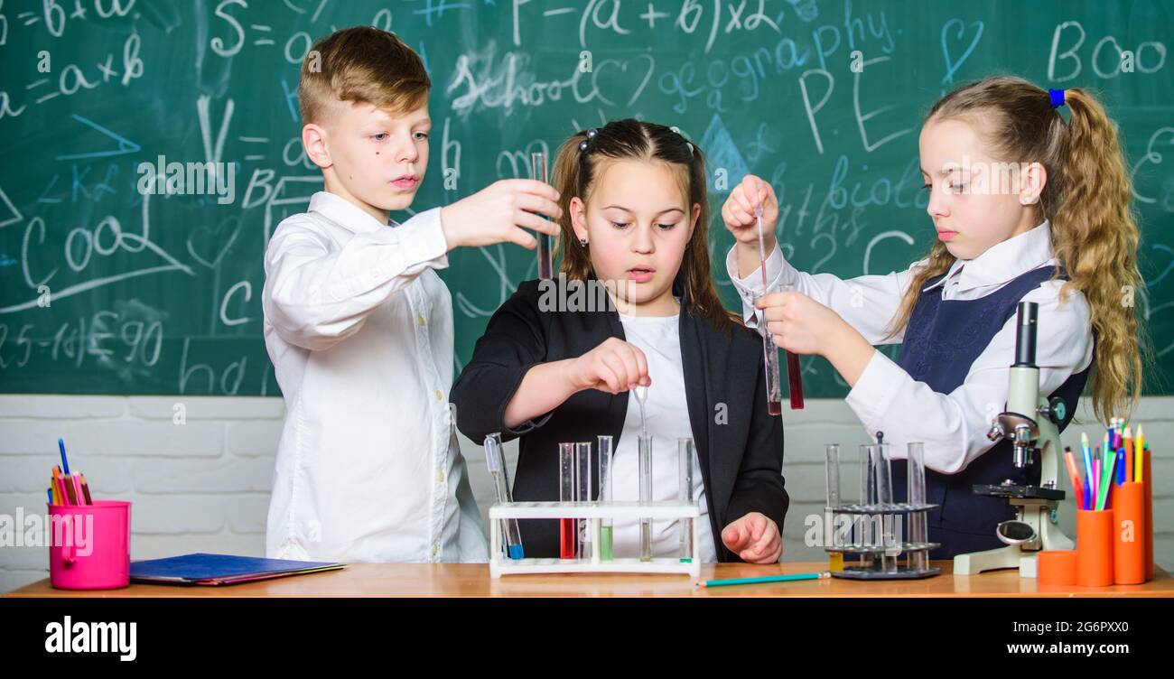 Little kids learning chemistry in school laboratory. students doing ...