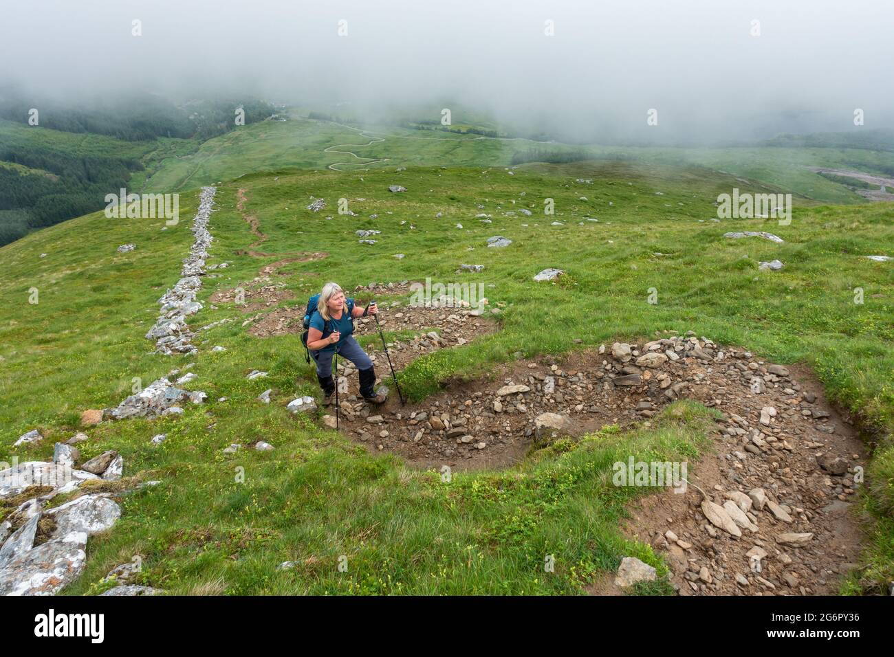 Female walker on the steep path up the Munro mountain of Ben More near ...