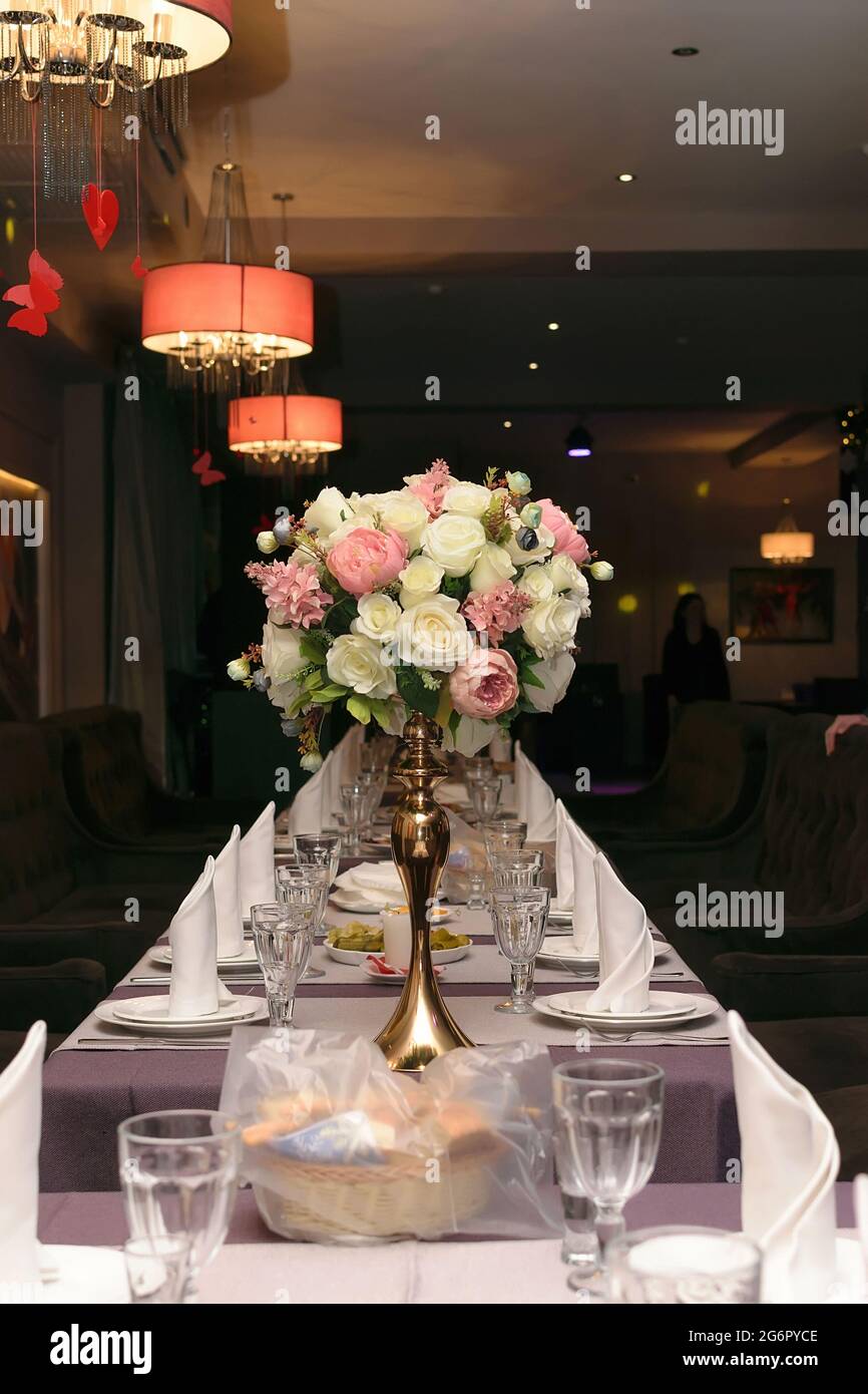 Beautifully served table in a restaurant with a bouquet of white and ...