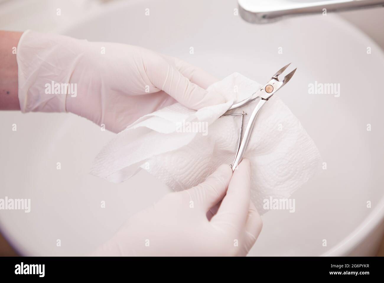 Close up of manicurist drying nippers with paper towel Stock Photo - Alamy