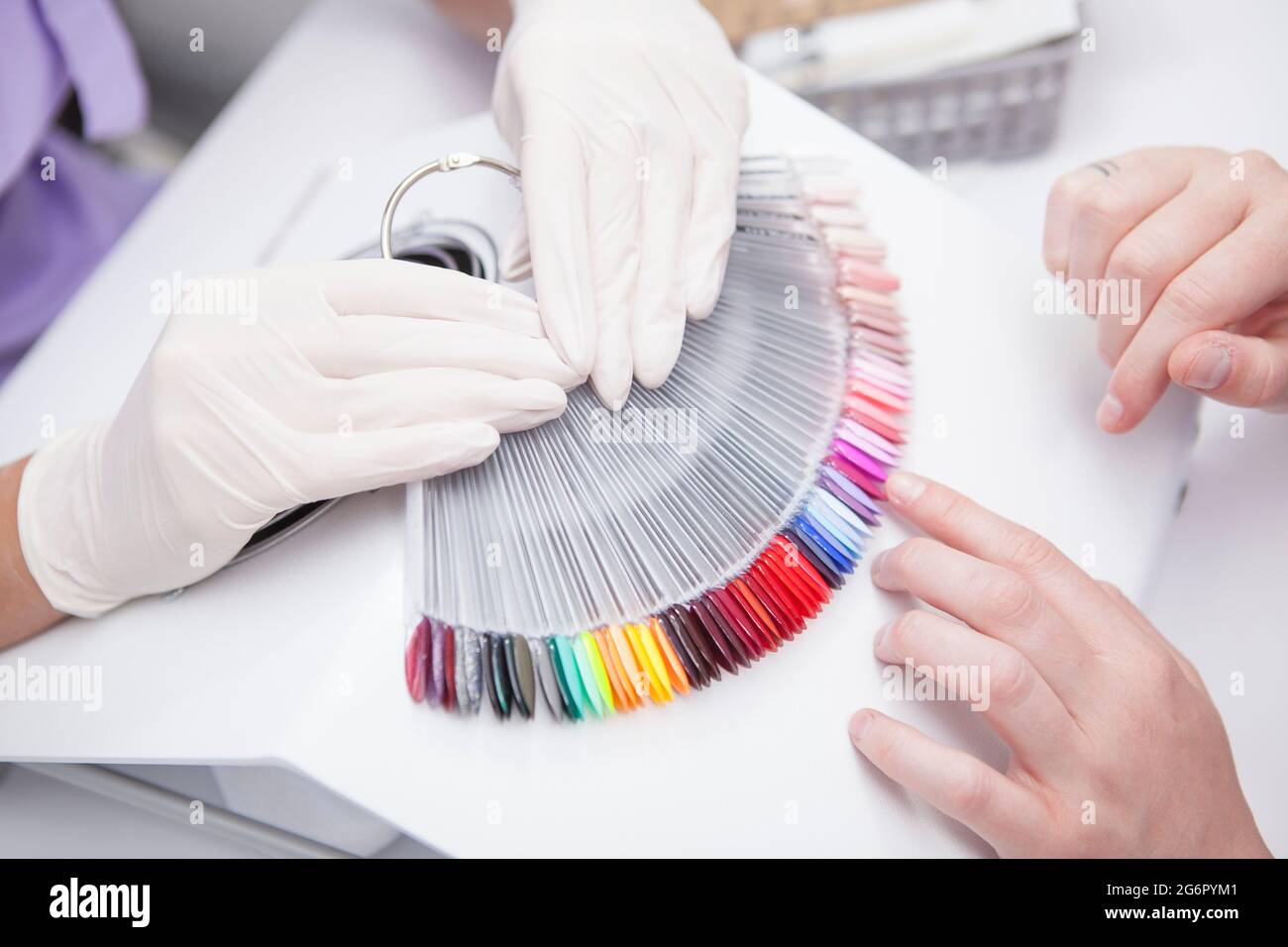 Professional manicurist showing her client nail gel color palette Stock ...