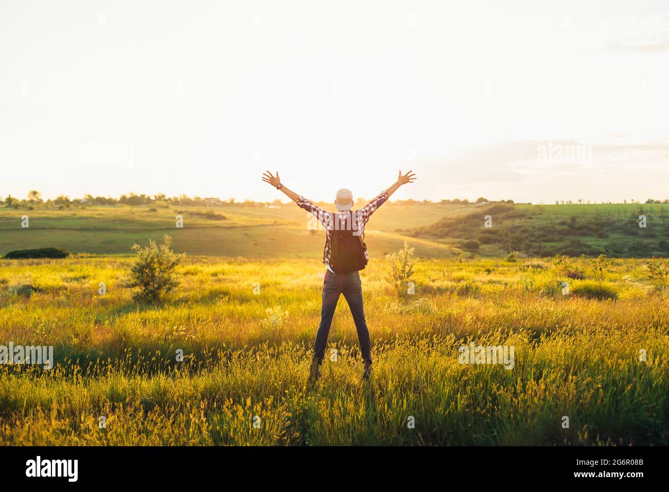 Rear view of man jumping up with outstretched arms, happy man with arms ...