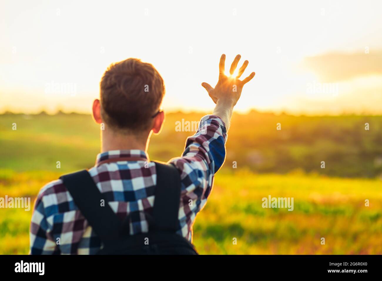 Back view, Human hand, tourist covering sunlight, Sun shining through ...