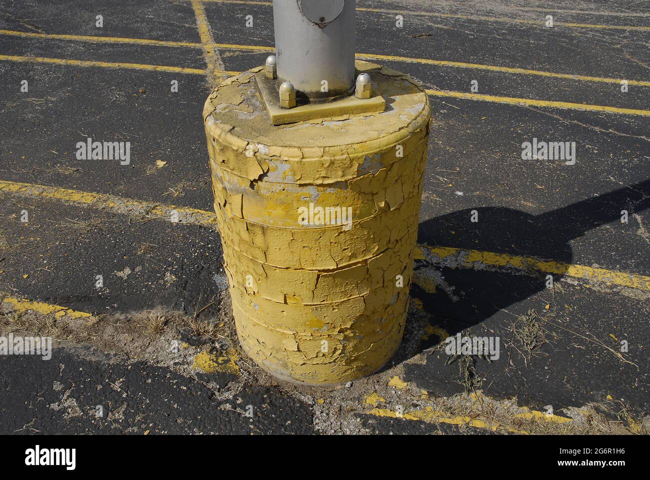 Closeup shot of the yellow concrete pier of a parking lot light pole in ...