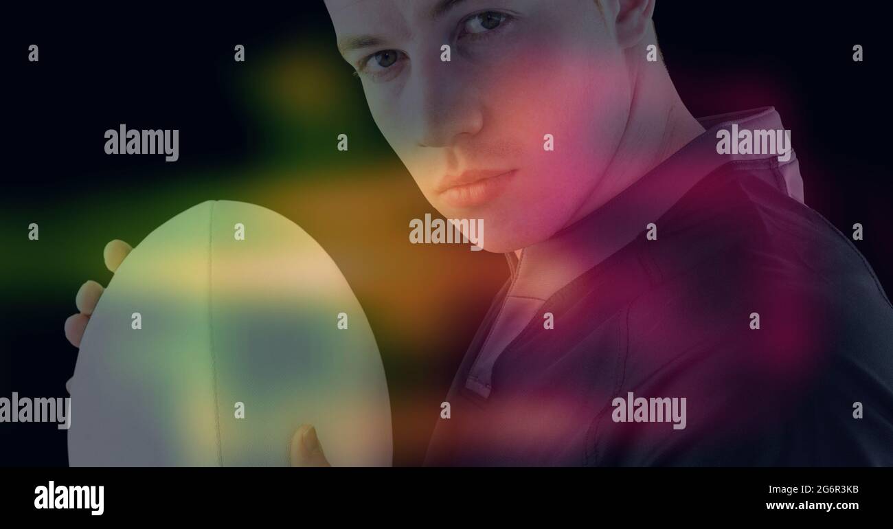 Composition of glowing yellow, blue and red blur over male rugby player ...