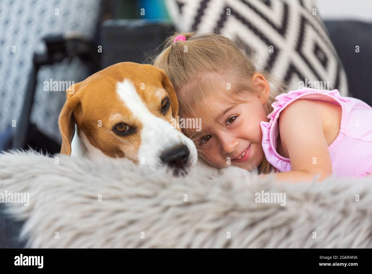 Child cuddle a dog on backyard sofa Stock Photo - Alamy