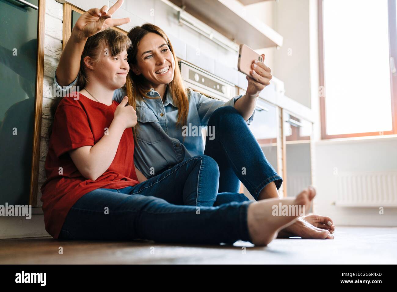 Woman and her daughter with down syndrome using cellphone while sitting ...