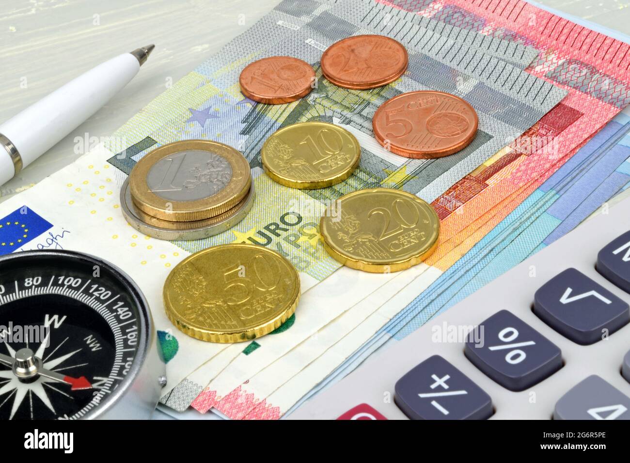 Euro notes and coins with compass, pen and calculator. A metaphor on ...