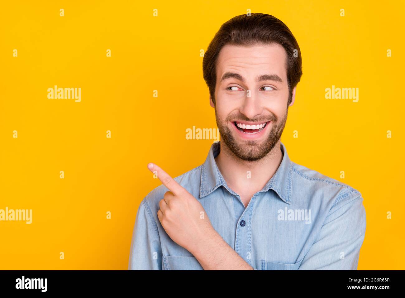 Photo portrait of young man smiling pointing blank space advising ...