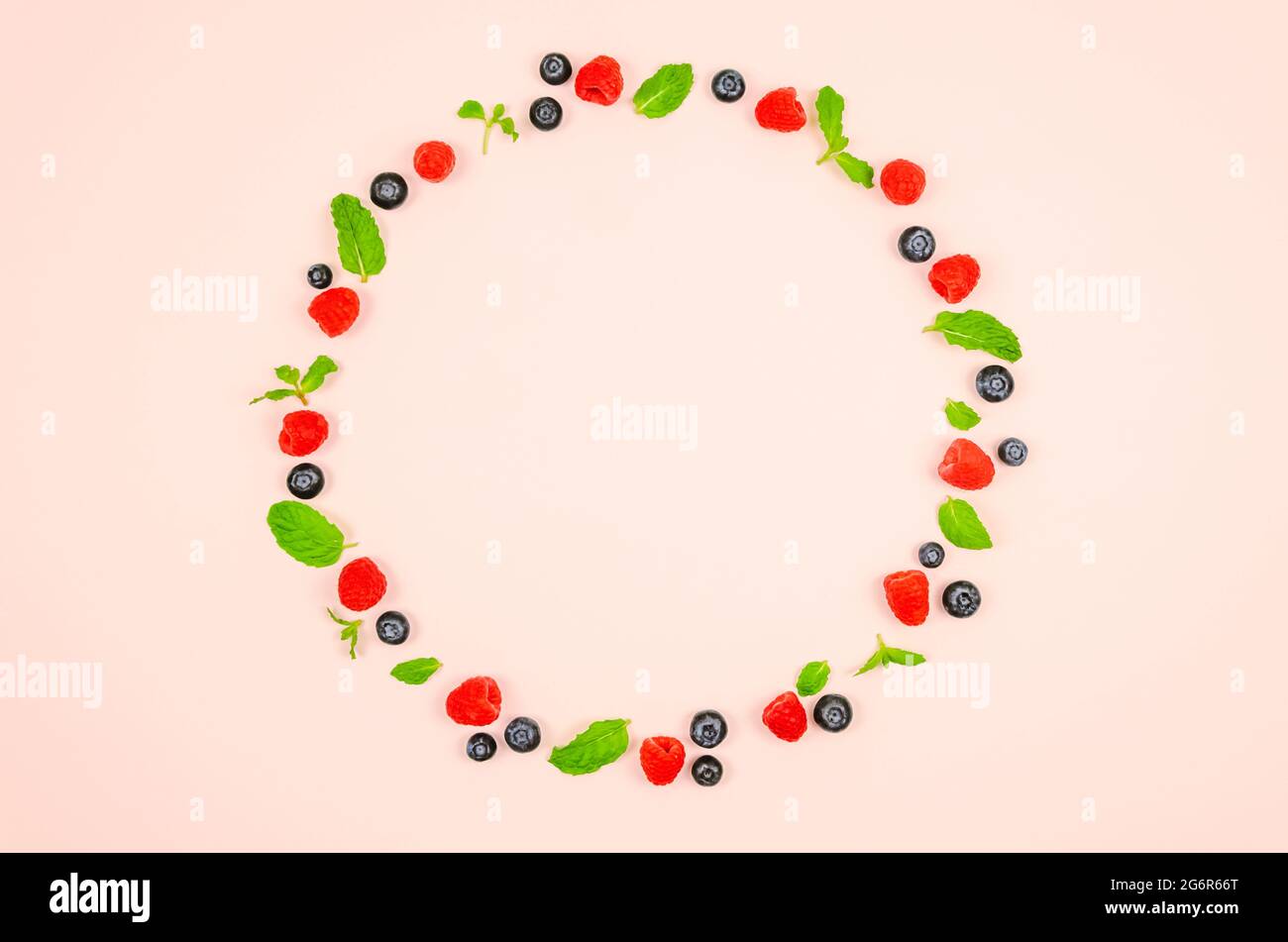 Fresh blueberries, raspberries and mint leaf on top view with pastel ...