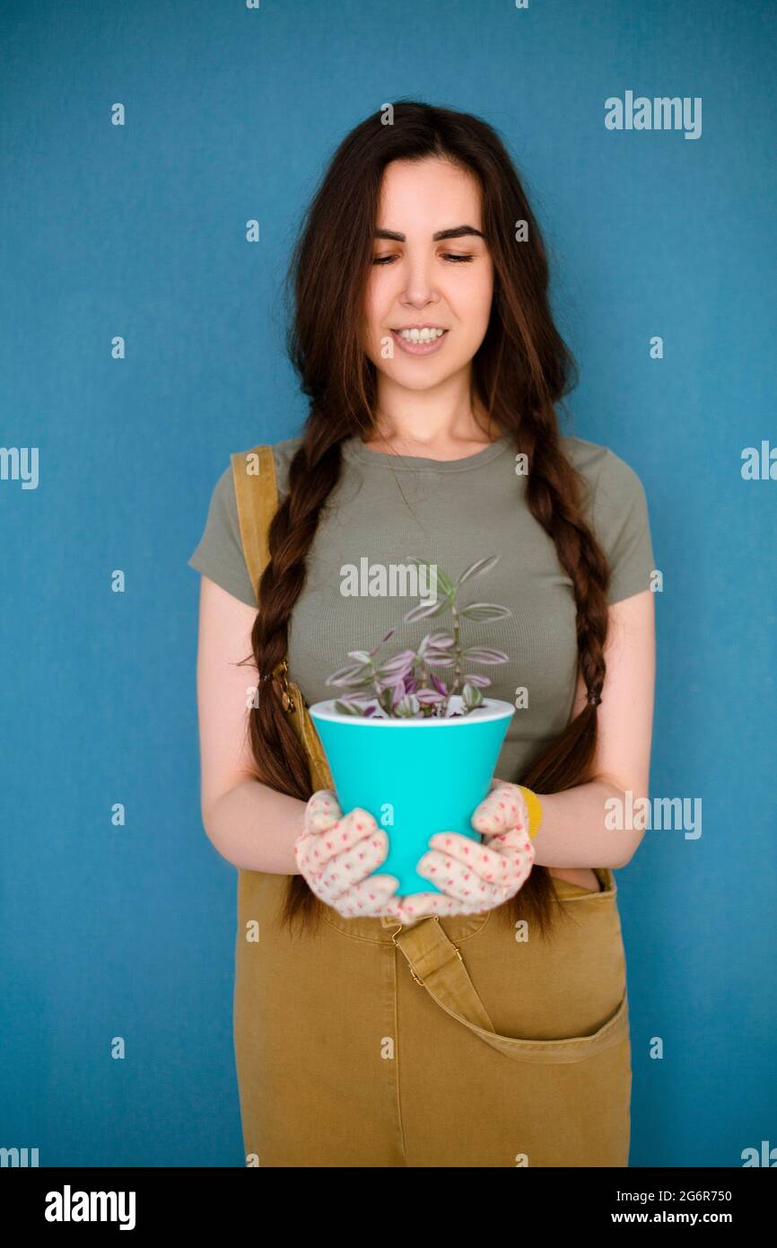 Young woman with braided hair smiling and demonstrating pot with ...