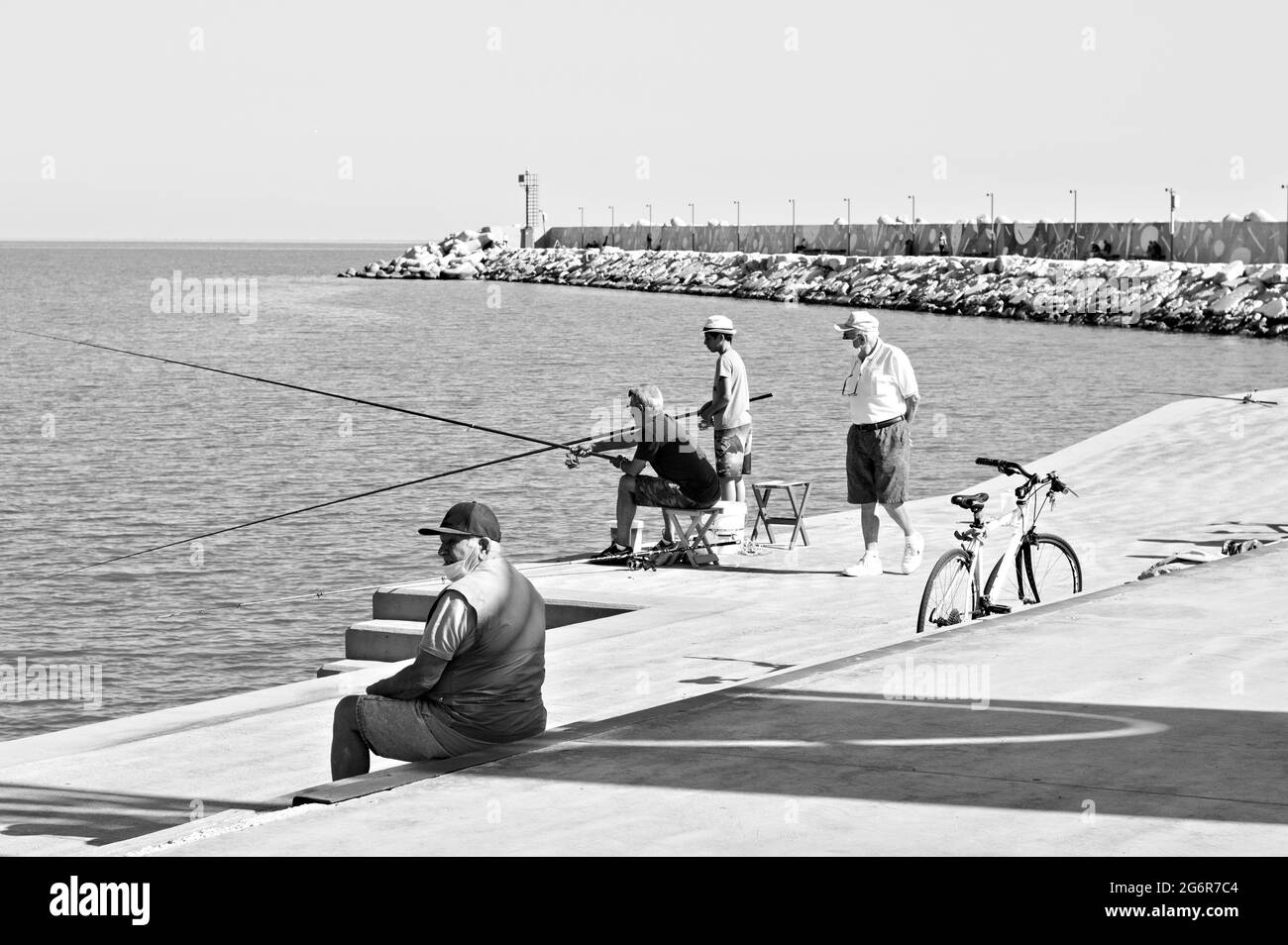 Pesaro, Italy - 9 july 2020: a little boy is fishing with his father ...