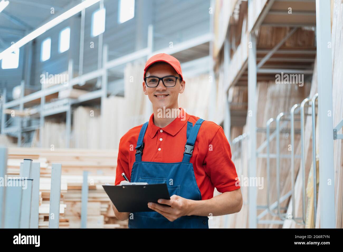 supervisor with a clipboard stands in a warehouse with a laminated ...
