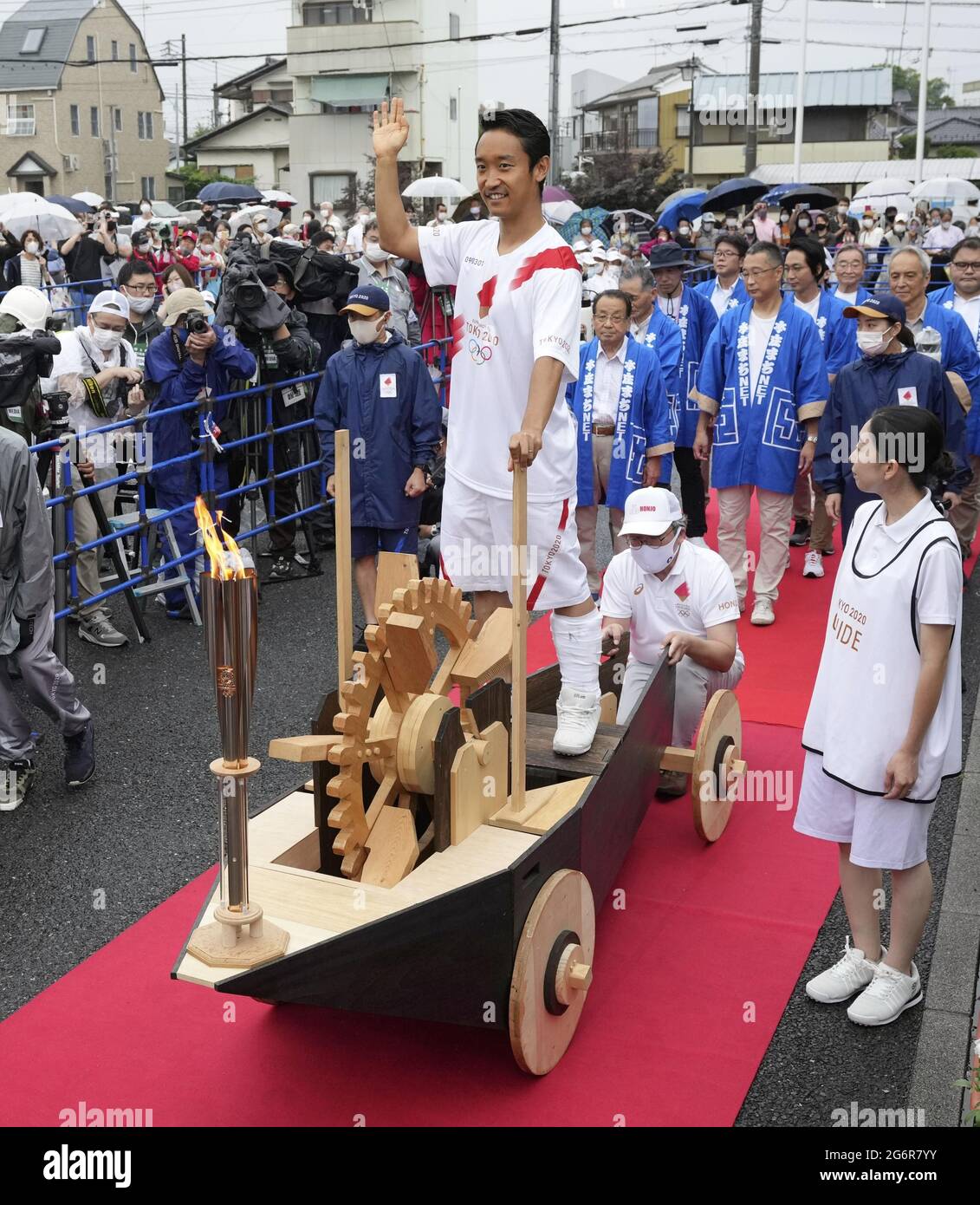Tokyo, Japan. 8th July 2021. A Tokyo Olympic torch relay runner waves ...