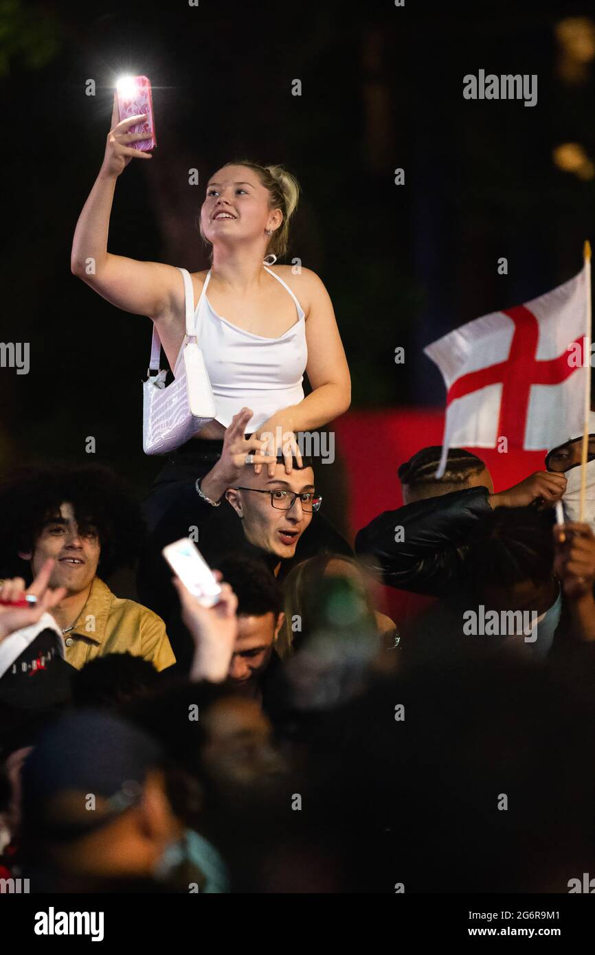 London, UK. 07th July, 2021. A women seated on someones shoulders ...