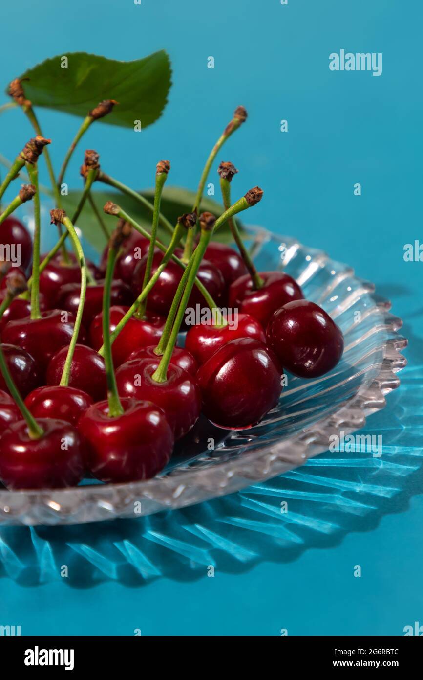 Ripe cherry on plate on blue background. Food for a good sleep. Cherry ...