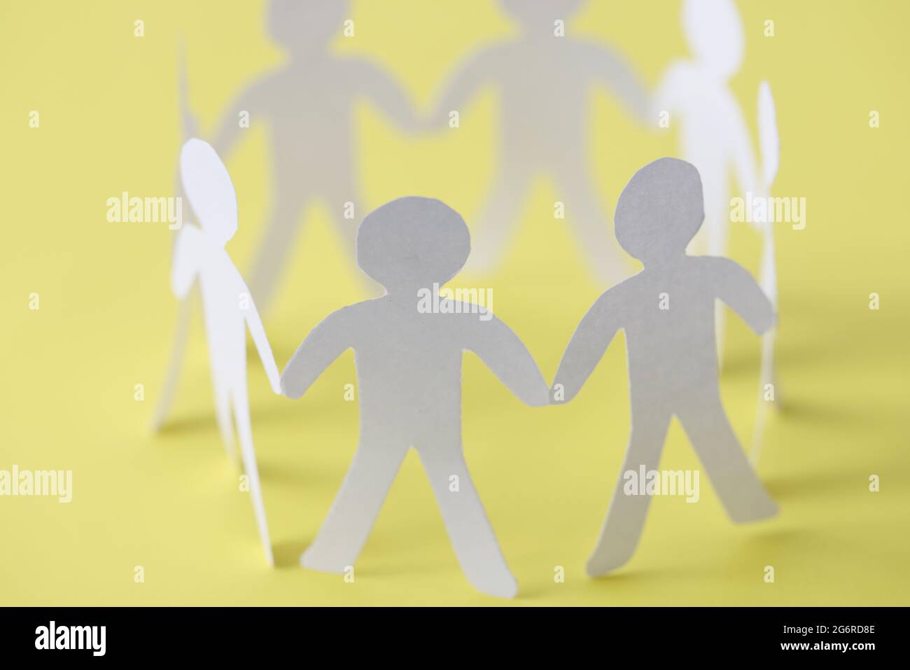 Cut paper people forming union circle on yellow background Stock Photo ...