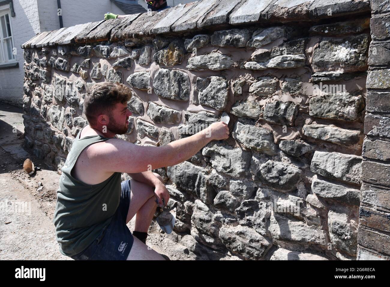 Construction worker builder repairing pointing old stone wall Britain ...