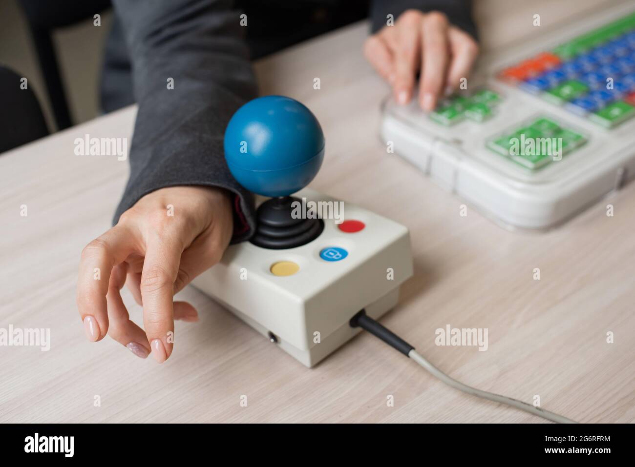 An unrecognizable woman with cerebral palsy is typing on the keyboard ...