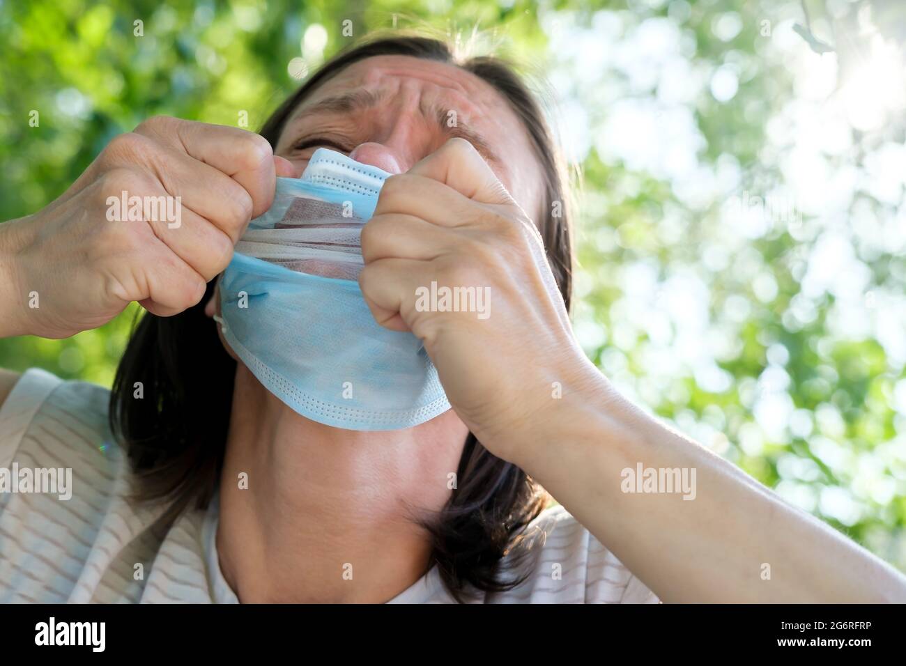 Woman emotionally tearing medical mask from his face, she gasps and ...
