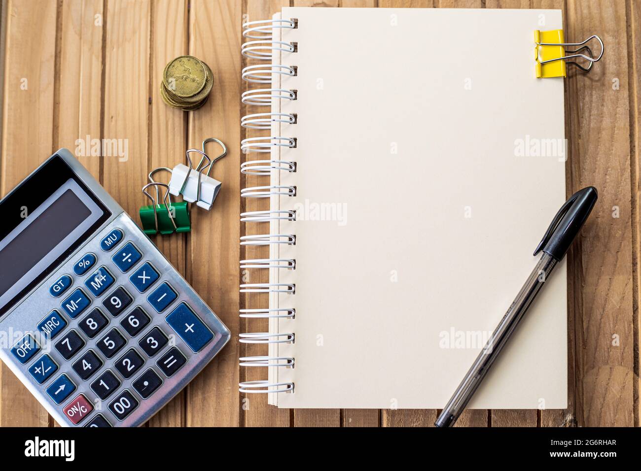 Plain Spiral Notebook With Pen Beside Calculator And Coins On Table ...