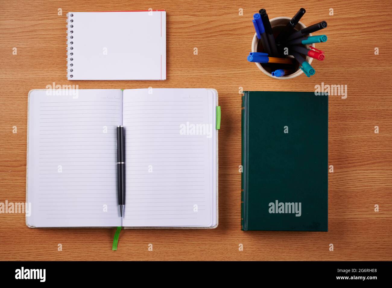 Plain Blank Open Notebooks With Stack Of Pens Inside Container Placed ...