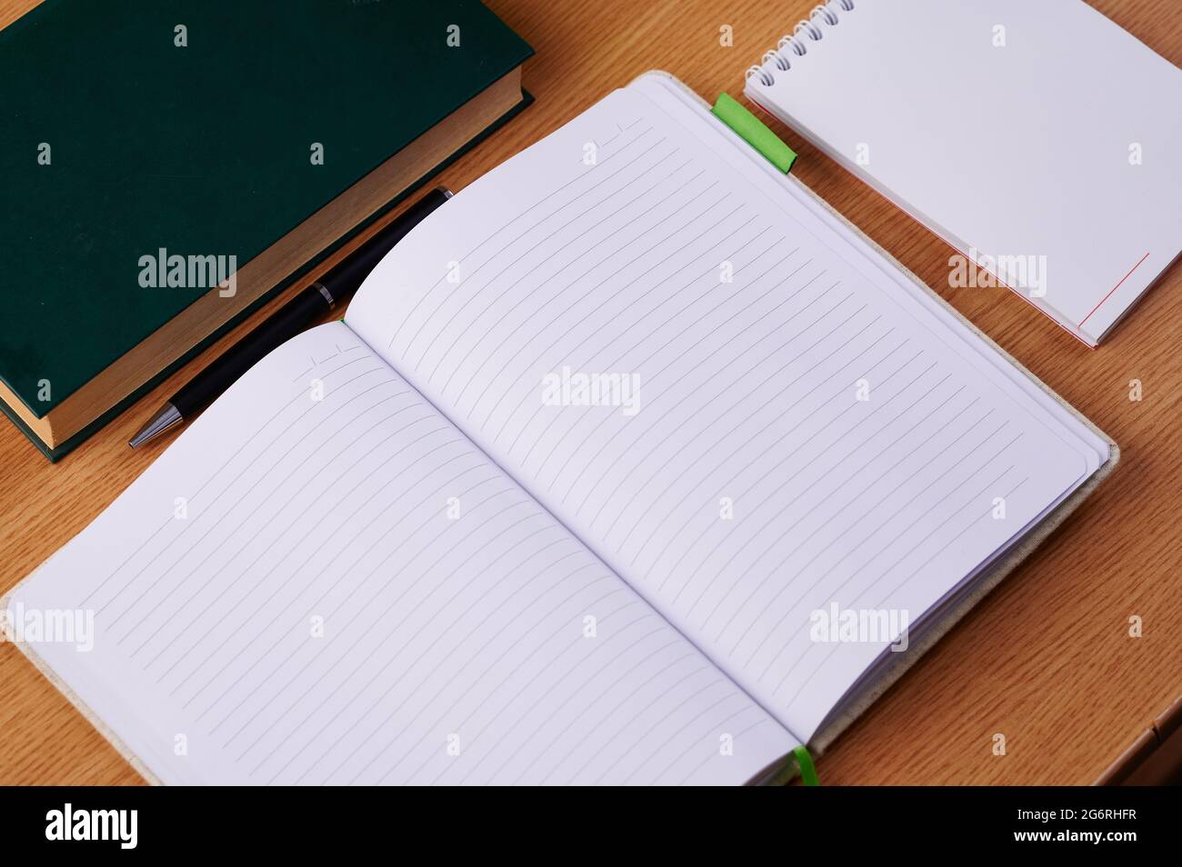 Plain Blank Open Notebooks With Stack Of Pens Inside Container Placed ...