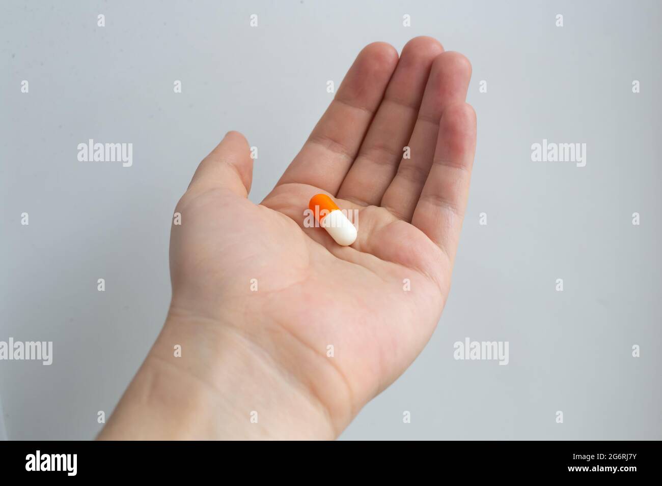 Big white and red color capsule pill on the palm, bacterial infection ...